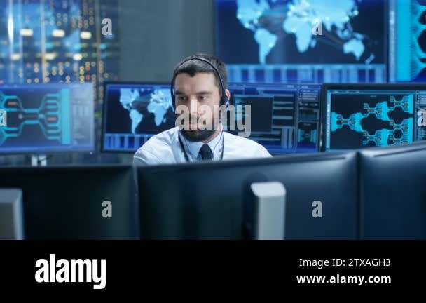 System Control Room Dispatcher Talks into Headset. He Controls Correct Work of the Facility. In ...