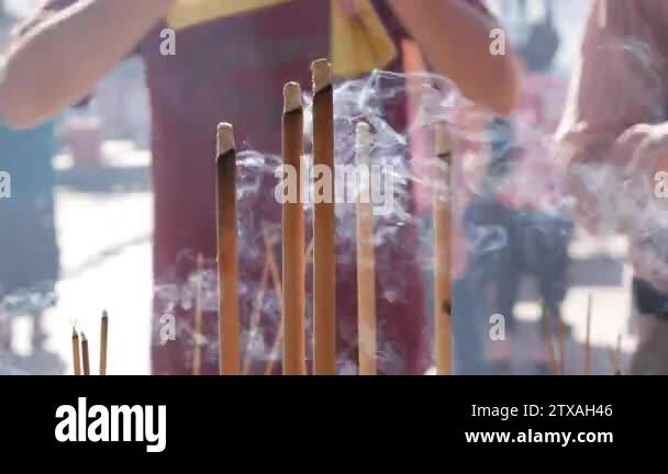 People praying and worshipping in Taoist temple interior bowing and ...