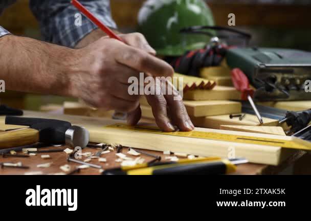 Adult carpenter craftsman takes the measure and with the carpenter's ...