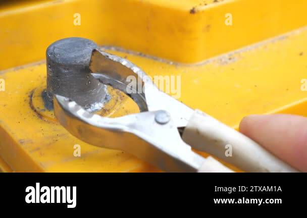 The male hand detach the terminals to the cars batteries for charging ...
