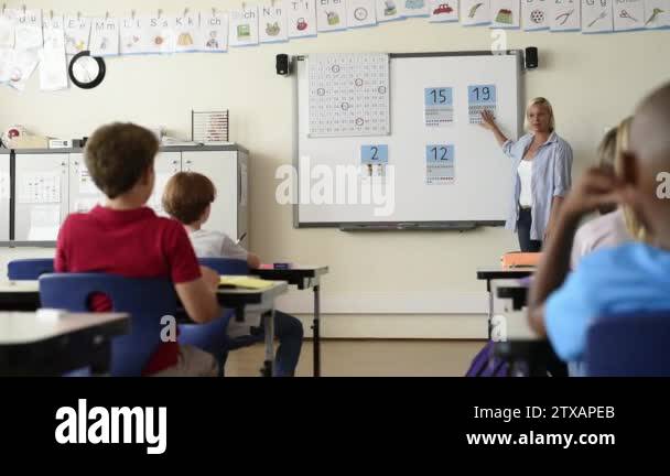 Teacher teaching how to count on whiteboard in the classroom. Woman ...