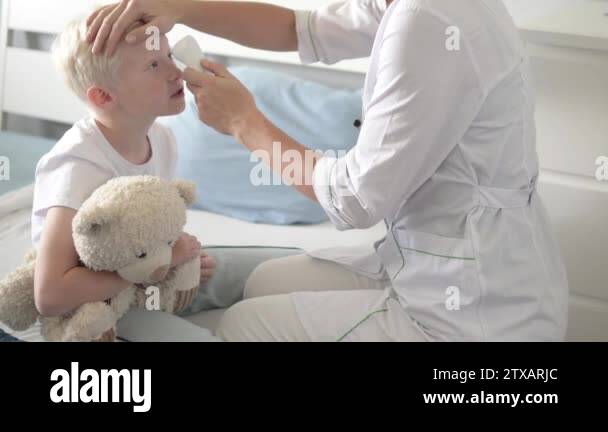The doctor measures the temperature of the child. A nurse brings an ...