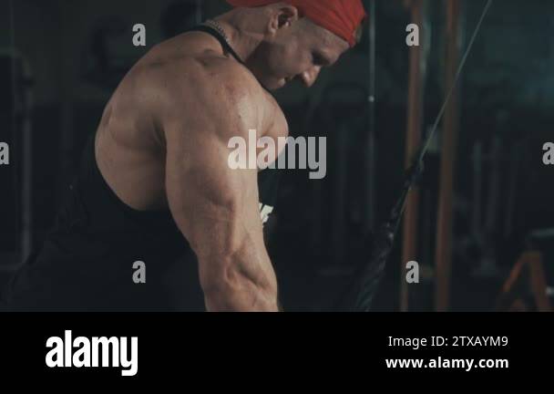 Bodybuilder in gym train arms triceps muscles using cable machine for ...