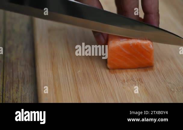 Asian chef slice salmon by knife on boad for japanese food delicacy consisting sashimi salmon of ...