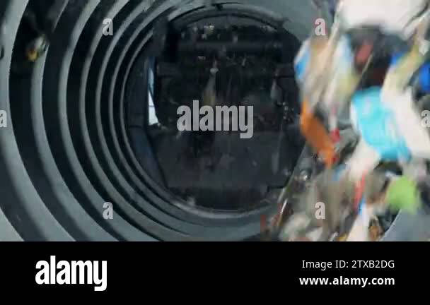 Process of mechanical garbage sorting. Trash falls from a conveyor into ...