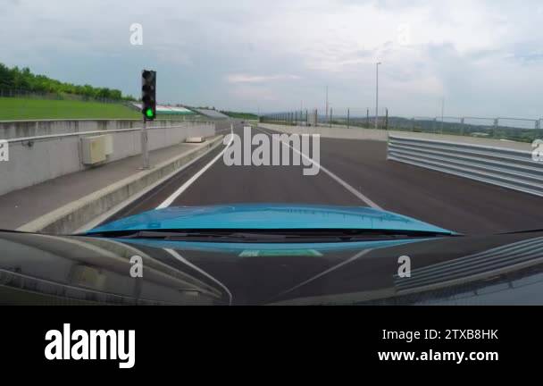 CLOSE UP LOW ANGLE VIEW: New blue personal sports car driving the lap ...