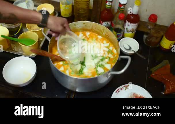 Cambodian man preparing traditional Khmer soup Khmer Curry, mixing all ingredients. 14 November ...