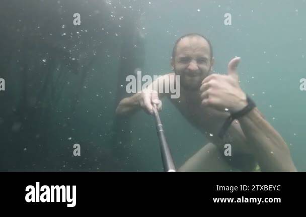 Underwater portrait of smiling man. Person having fun in swimming pool ...