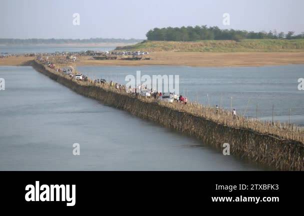 Traffic jam on the bamboo bridge over the Mekong River; motorbikes ...