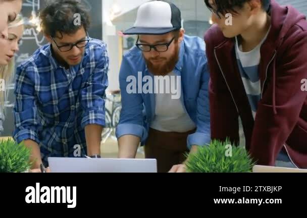 Team of Young Creative Developers Have Brainstorming Session at their Meeting Table, Discussing ...