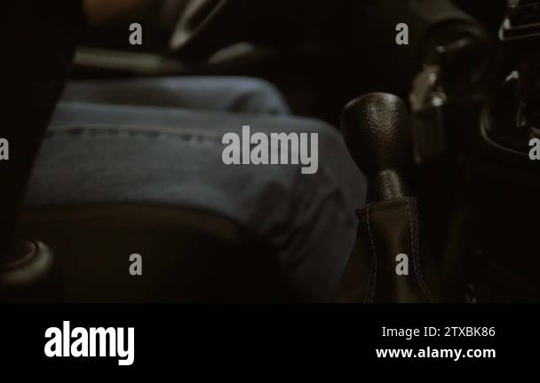 A woman's hand is shifting the change gear in a black leather cabin of ...