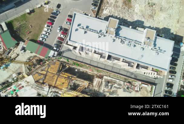 Construction site. Parking. Orthogonal shot moving backwards. Cranes ...