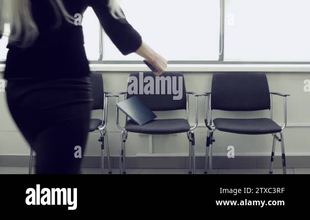 Woman in a strict suit comes in for an interview and sits on a chair ...