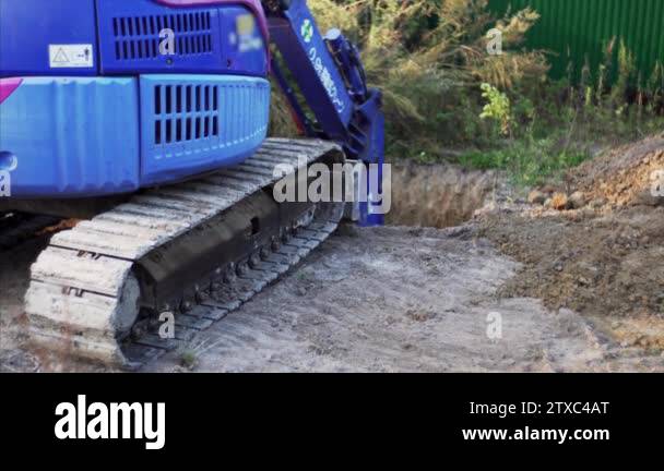 Hydraulic digger digging hole in ground for digestion tank at ...