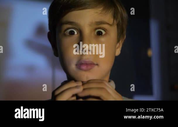 Little Scared Boy watching Horror Film or Video on TV or Computer in ...