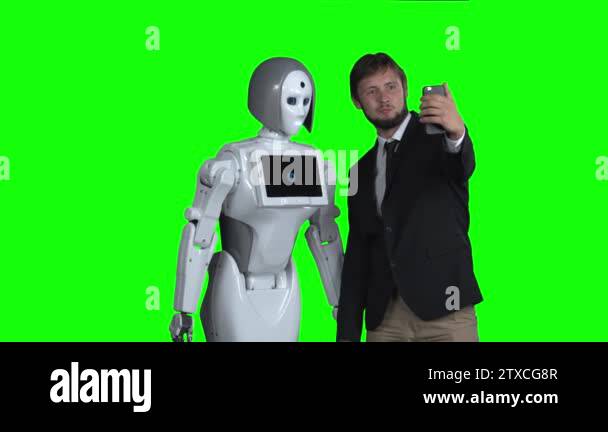 Guy with the robot is photographed and take a selfie. Green screen ...