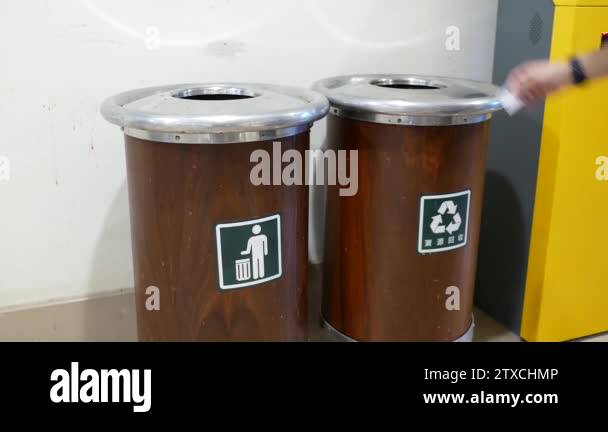 Motion of woman throwing trash to the garbage can inside shopping mall ...