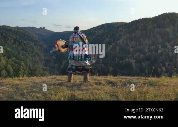 Siberian shaman performs a ritual dance and beats a tambourine on the ...