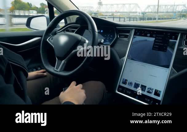 Driver types on a monitor while a car going on autopilot, close up ...