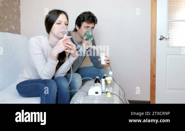 Use nebulizer and inhaler for the treatment. Man and woman inhaling ...