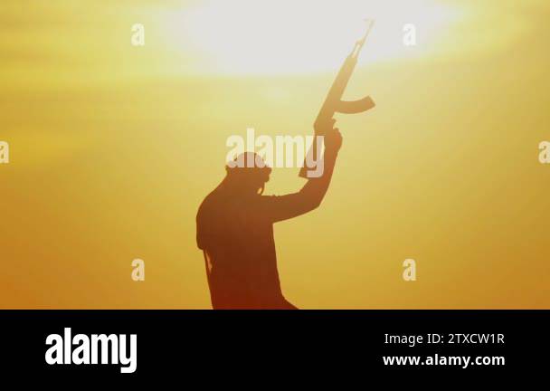Islamic warrior with Kalashnikov at sunset day. Muslim fighter is ...