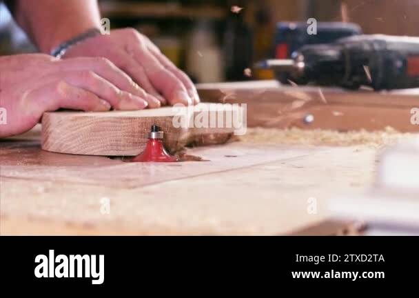 A carpenter is chamfers an edge from a compartmental dish on milling ...