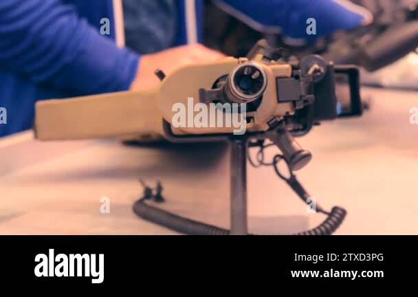 Weapon optics sight of sniper rifle with man close-up in store or shop ...