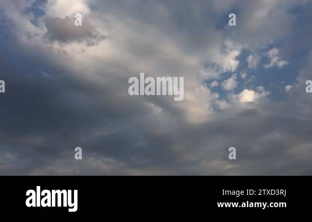 White sunset clouds disappear in the hot sun on blue sky. Loop features ...