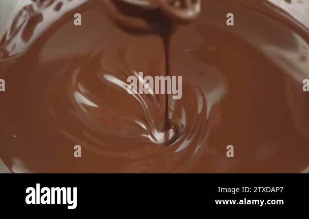 Close up of Chocolate. Mixing melted liquid premium dark chocolate with ...