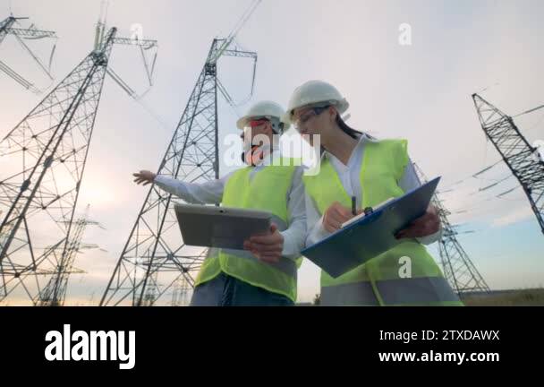Engineers work with a tablet on power lines. Power lines, power ...