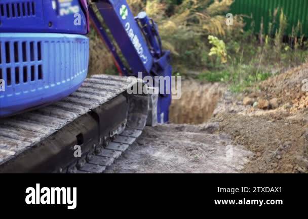Hydraulic digger digging hole in ground for digestion tank at ...