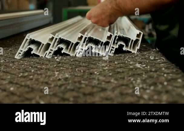Production of pvc windows, the worker screws a metal profile to the ...