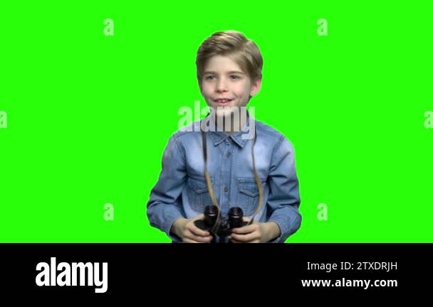 Little boy in denim jacket observing locations using binoculars. Green ...