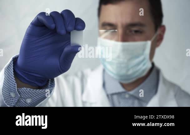 Close-up doctor looking of the hands in lab technician on a glass plate ...