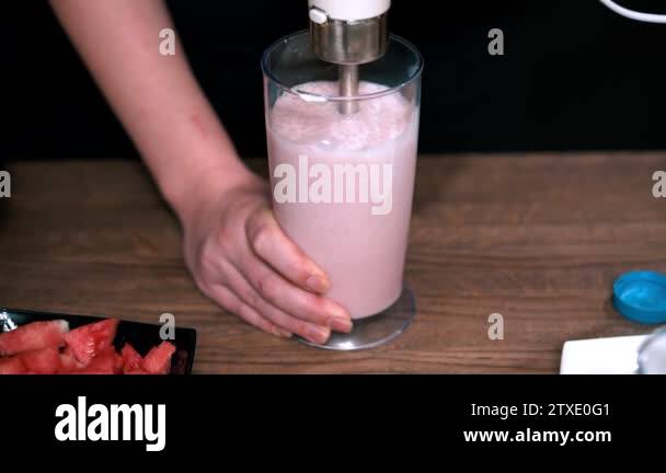 The process of mixing a mixture of milk, ice cream, banana and ...