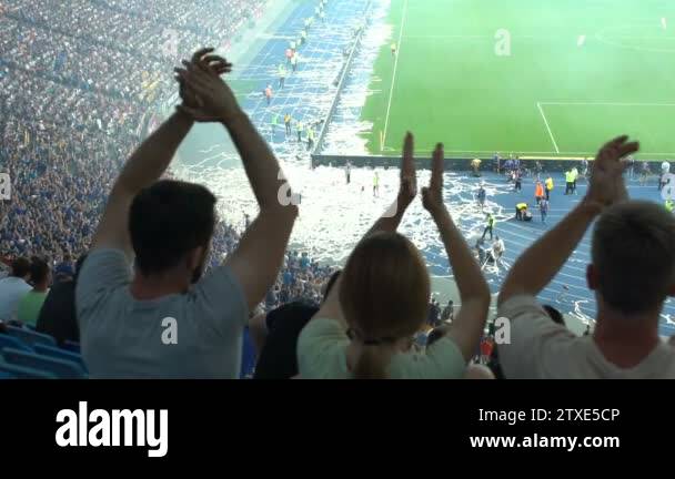 Football fans chanting and clapping hands, supporting national team at ...