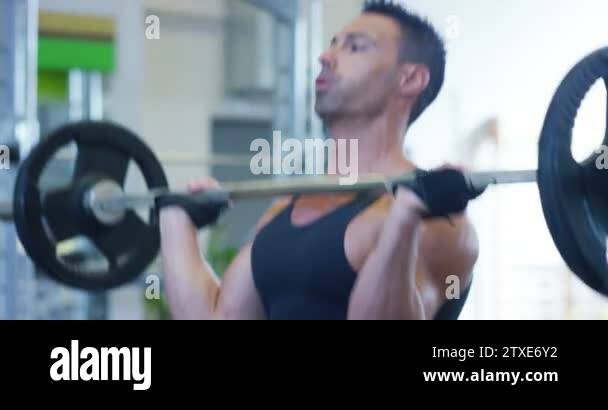 Guy bodybuilder in the gym, works with a barbell, bench press ...