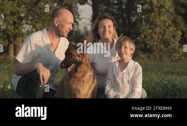 Happy family with a dog in nature. 7 year old boy with his parents ...
