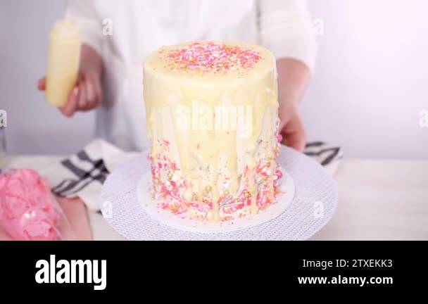 Step by step. Dripping a white chocolate ganache on birthday cake with ...