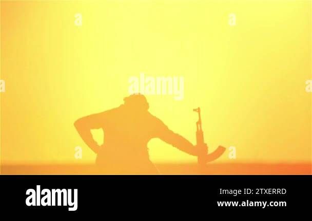 Islamic warrior with Kalashnikov at sunset day. Muslim fighter is ...