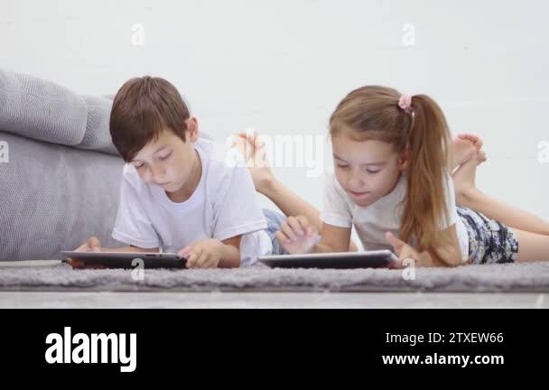Two kids with gadgets. Sister and brother surfing the net or playing ...
