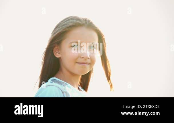 Portrait of attractive little girl with a big green eyes on nature background with developing ...