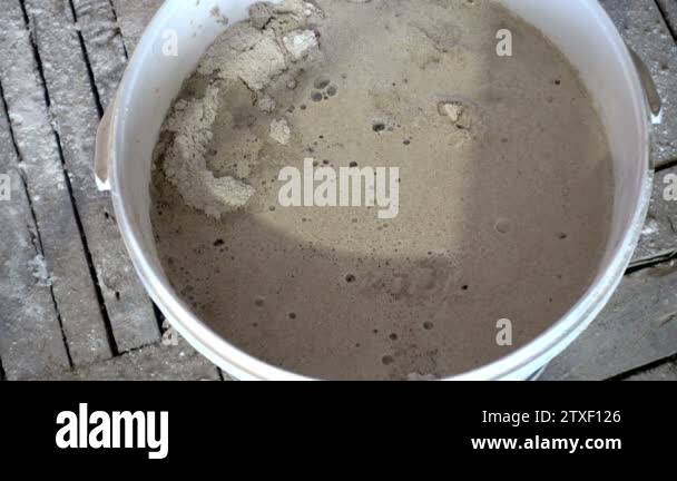 Builder mixes dry construction mixture, plaster, stuffing with manual ...