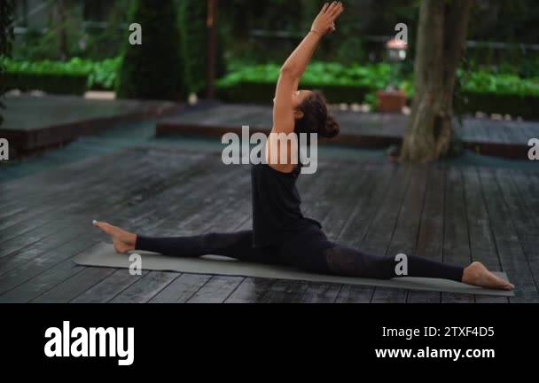 Girl doing split twine. Hanumanasana, monkey pose. Young woman with ...