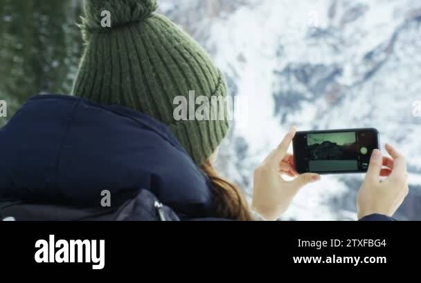 in mountains on vacation A girl uses a mobile phone or smartphone for ...