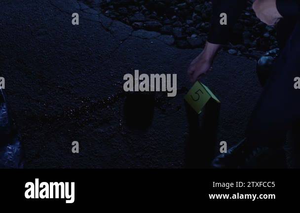 Forensics expert putting evidence number and looking at dead girl in ...