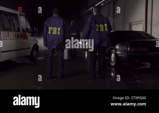 FBI agents work at the scene at night, police car with lights and ...