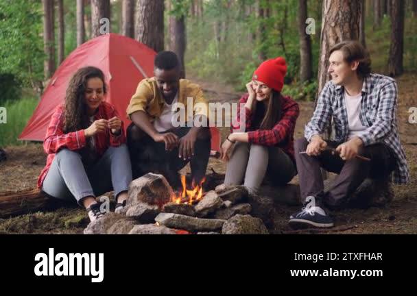 Joyful tourists men and women are sharing stories sitting around ...