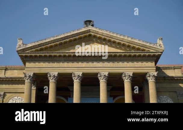 Facade of ancient building with columns and triangular portico. Action. Beautiful historical ...