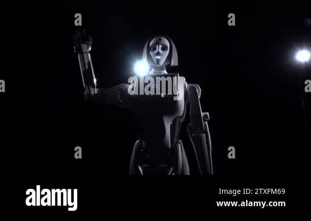 Robot talks and repeats various movements bye . Black background Stock ...